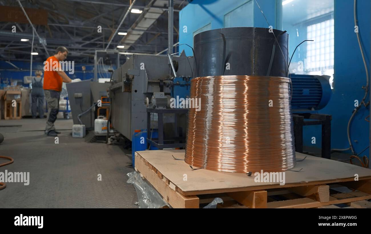 Copper wire on industrial coil with working. Creative. Worker adjusts ...