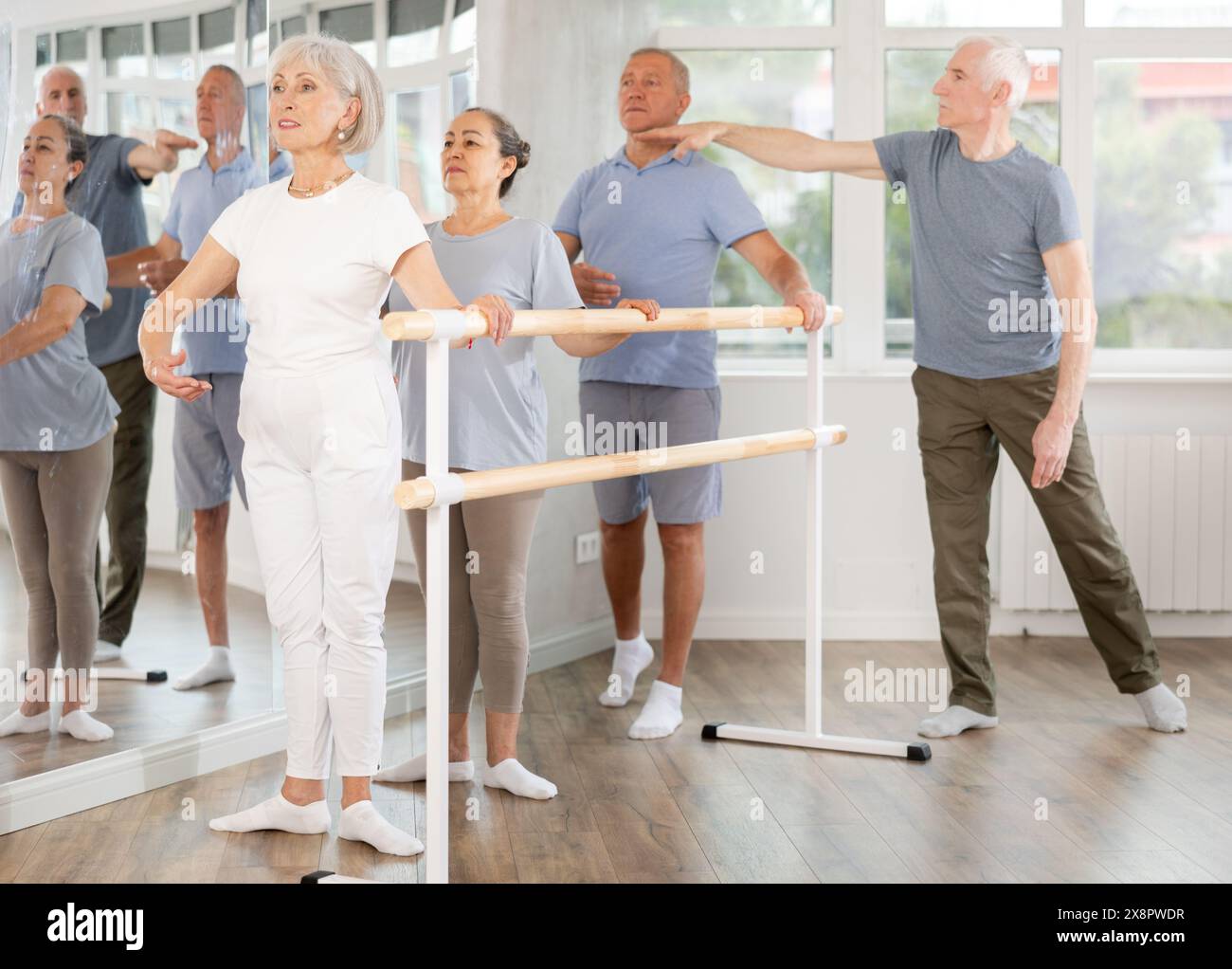 Group of elderly dancers engaged in ballet in dance studio perfoms ...