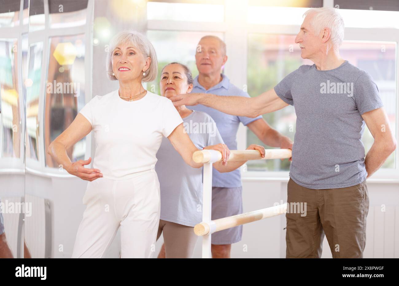 Group of elderly dancers engaged in ballet in dance studio perfoms ...