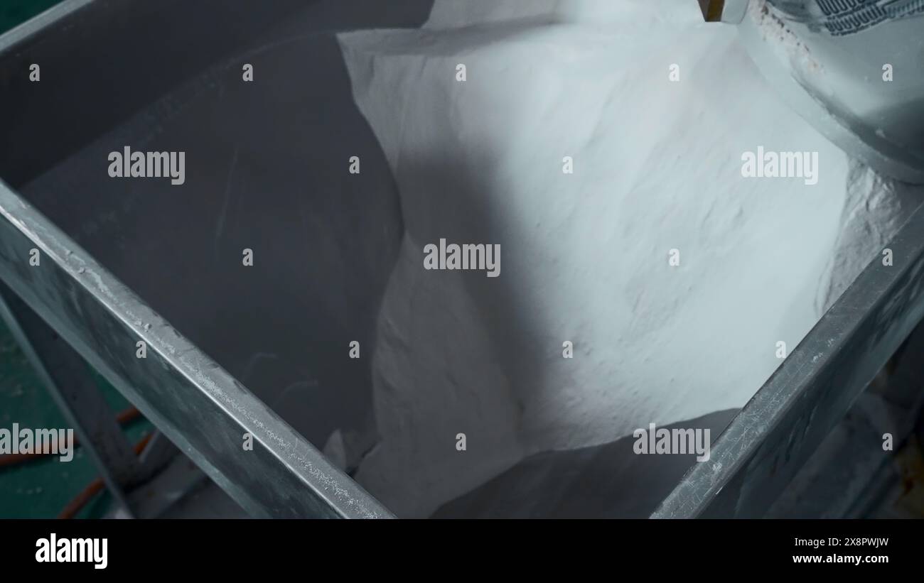 Plastic powder at factory. Creative. Pipe with spilling plastic powder ...