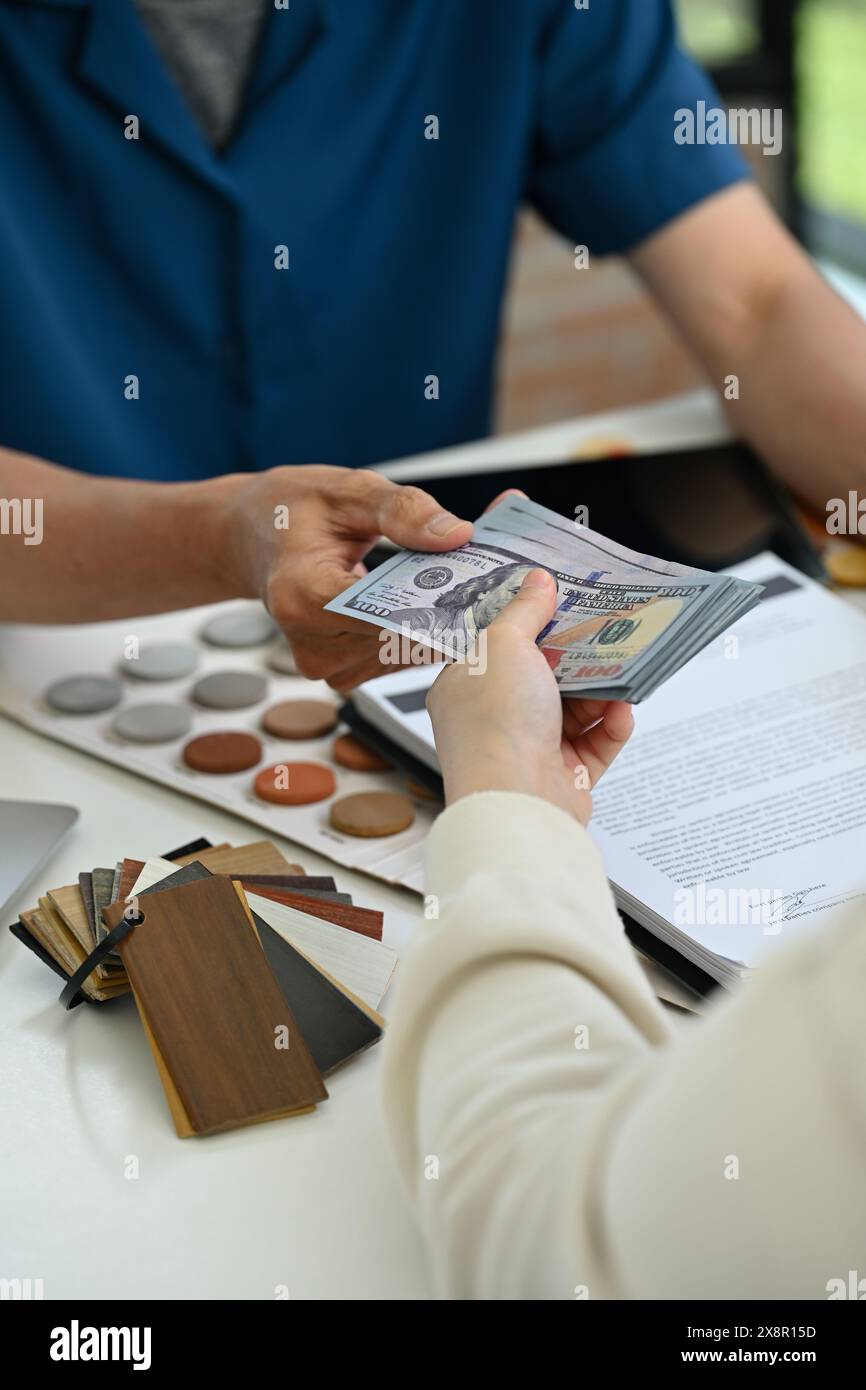 Cropped shot unrecognizable male contractor receiving money from female ...