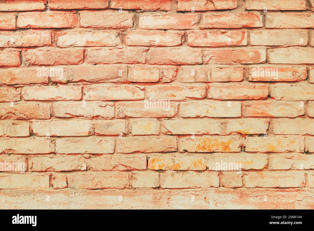 Old brick wall facade painted in peach fuzz color as background Stock ...