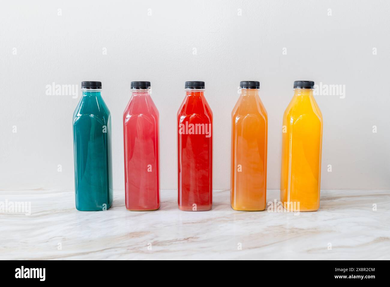 Colorful beverage bottles lined up on marble counter, bright drinks ...