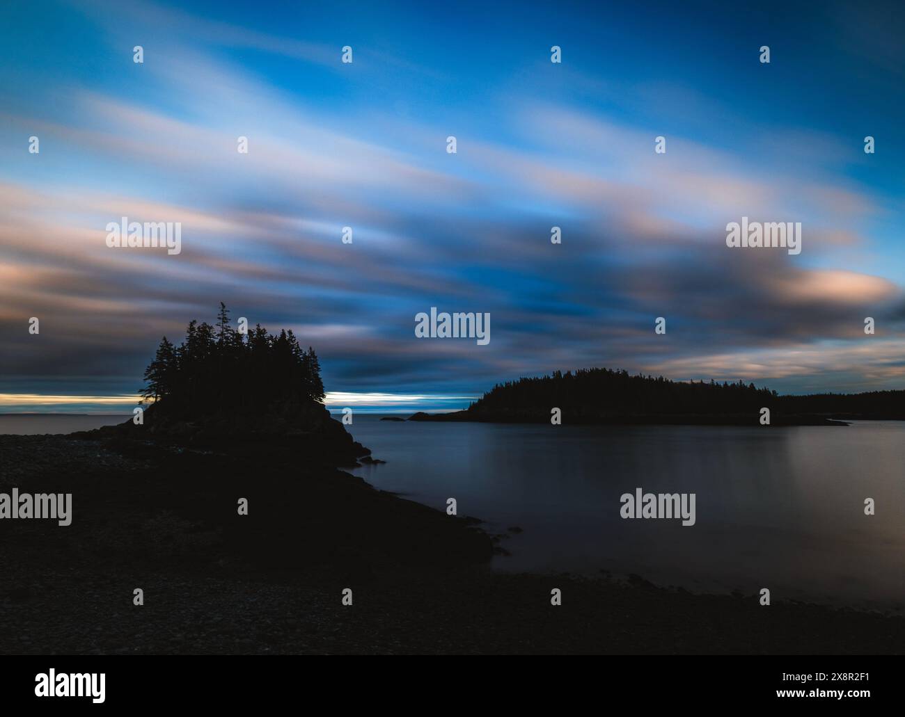 Long exposure passing clouds over island along coast, Cutler, Maine ...