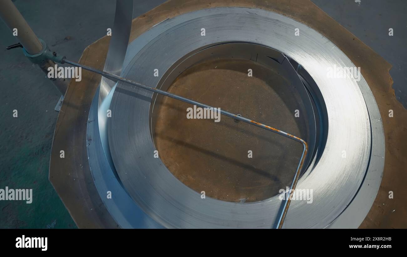 Unwinding metal line on machine. Creative. Coil of flat metal line on ...