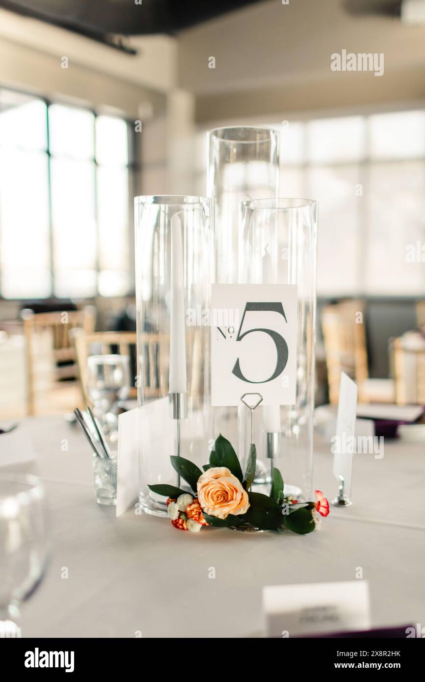 Table centerpiece with candles, flowers, and a table number card Stock ...