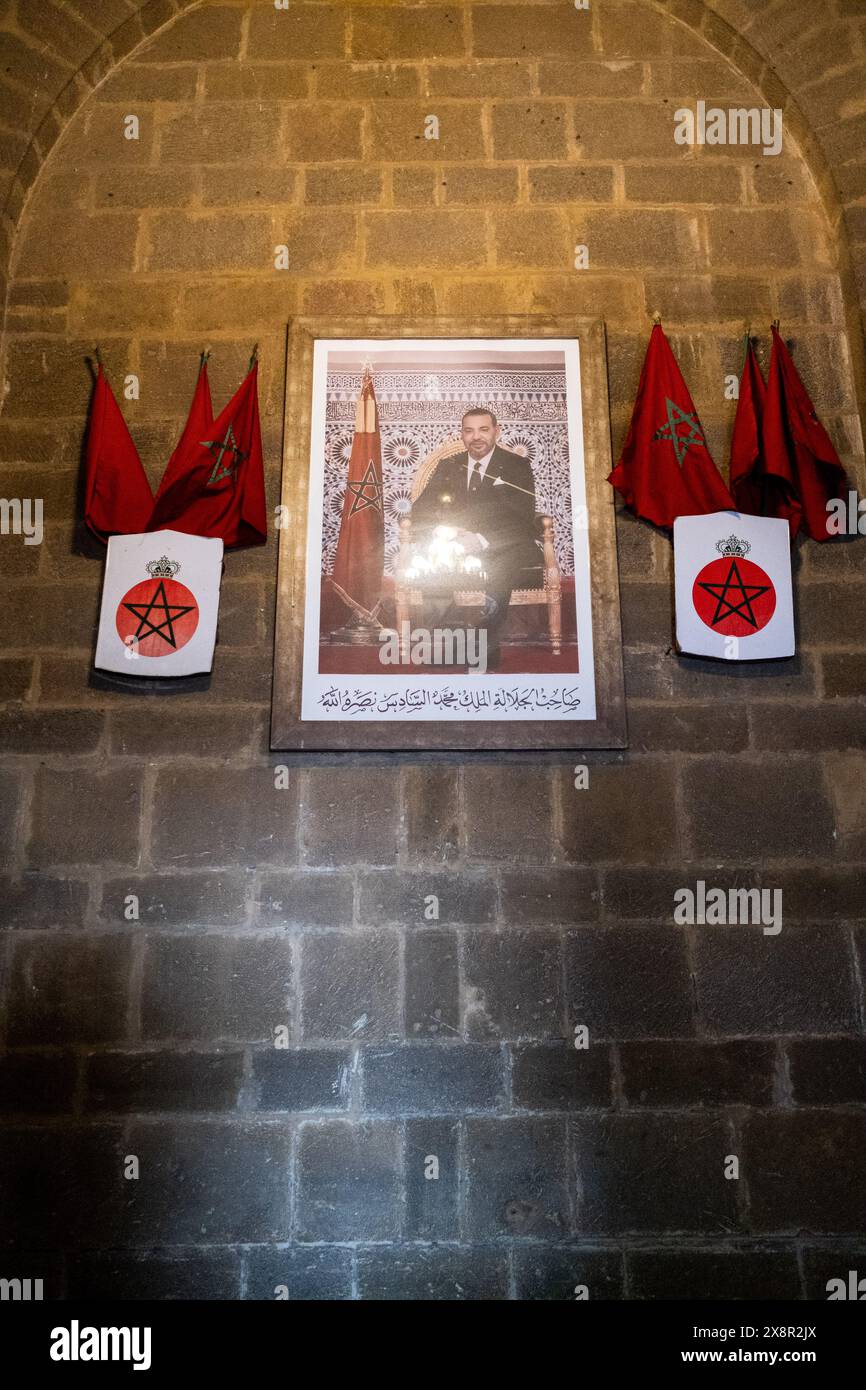 A portrait of King Mohammed VI with Moroccan flags at the Mahkama of ...