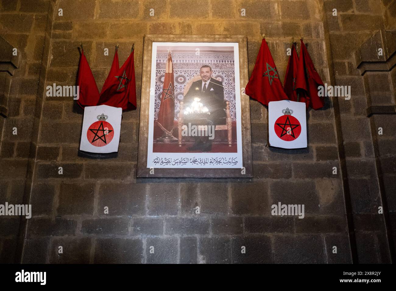 A portrait of King Mohammed VI with Moroccan flags at the Mahkama of ...