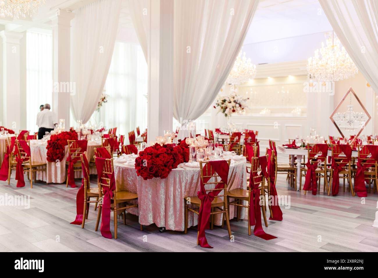 Wedding reception with red and gold decor and floral centerpieces Stock ...