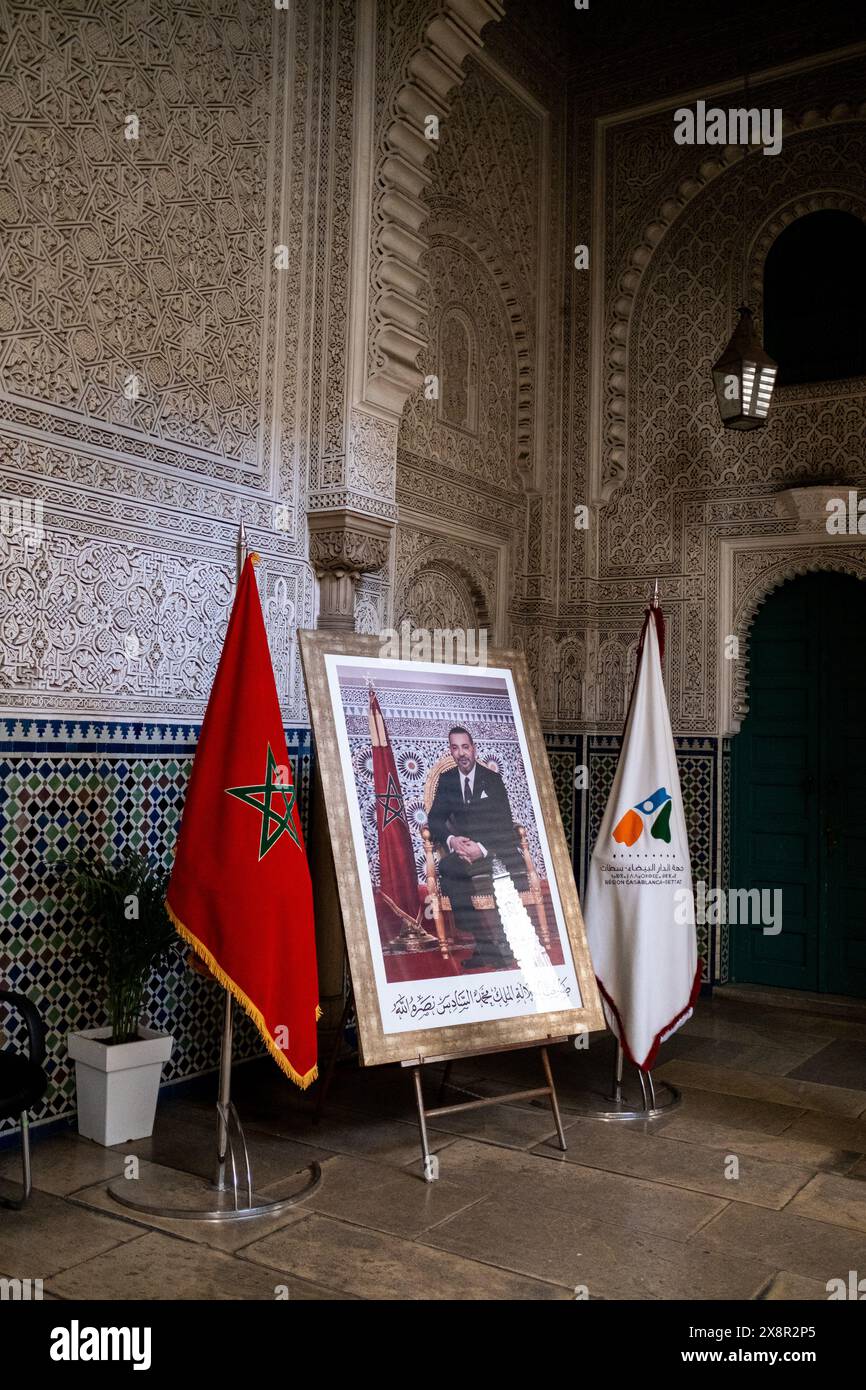 A portrait of King Mohammed VI with Moroccan flags at the Mahkama of ...