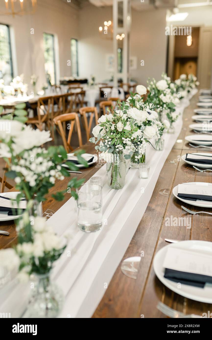 Long reception table with elegant white floral decor Stock Photo - Alamy