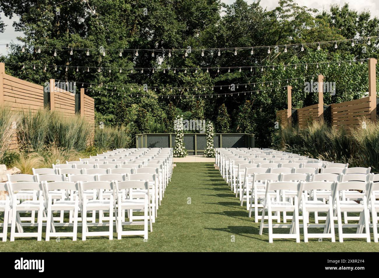 Outdoor wedding setup with chairs and lights Stock Photo - Alamy
