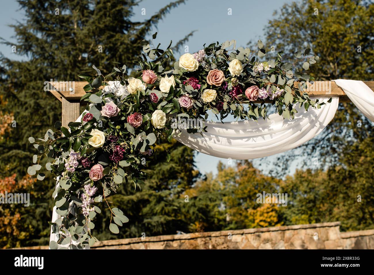 Floral-decorated wooden wedding arch with drapery, set outdoors Stock ...