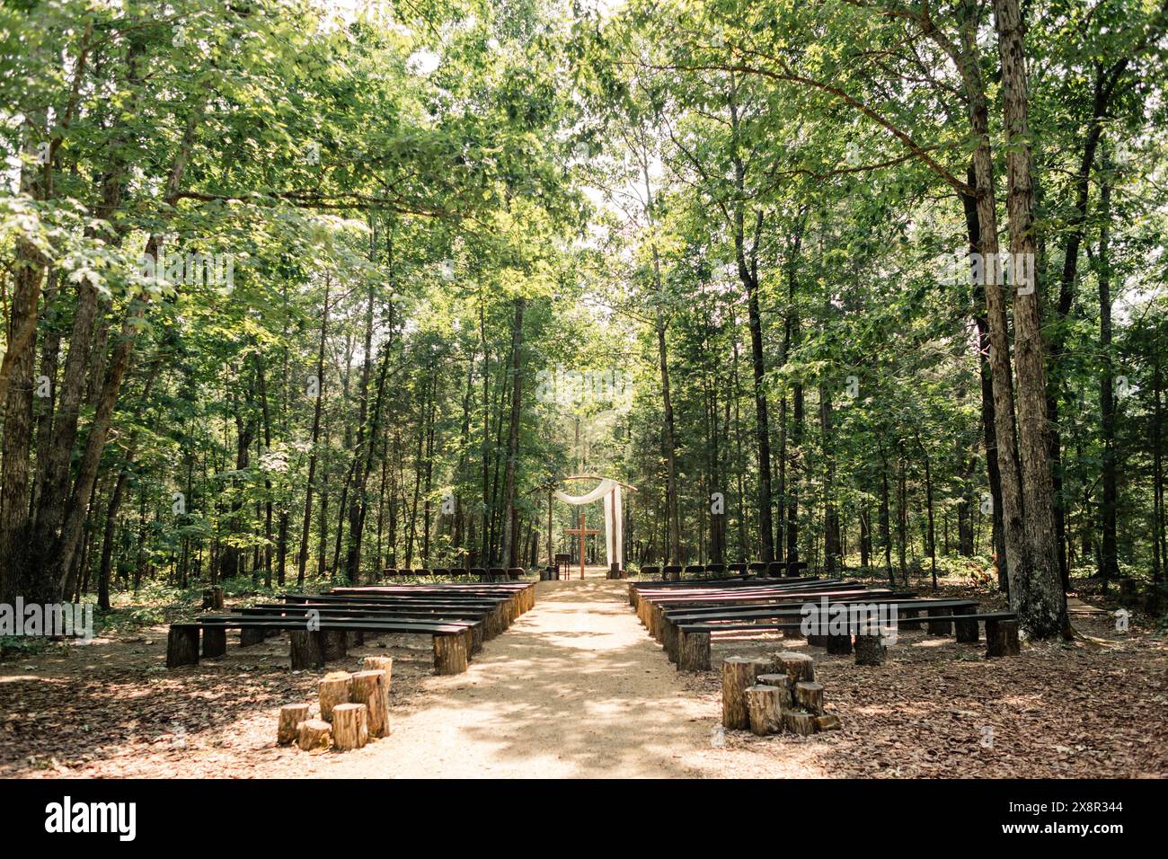 Rustic outdoor forest wedding ceremony with wooden benches and arch ...