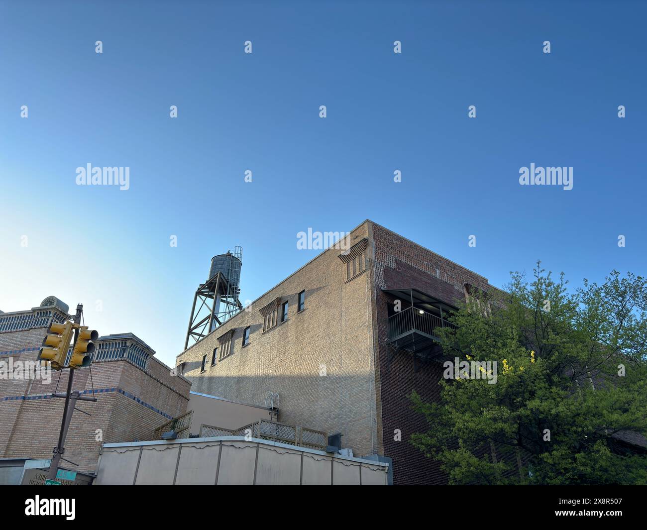 Water tower on building under a clear blue sky in Queens, NY Stock ...