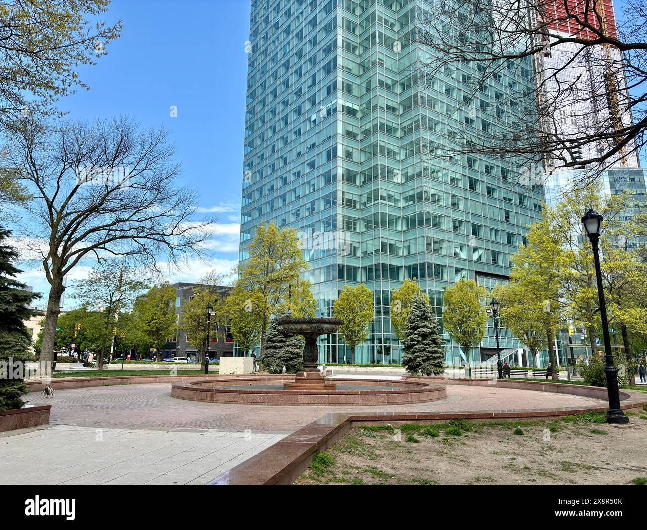 Modern glass building and plaza with trees and fountain in Queens, NY ...