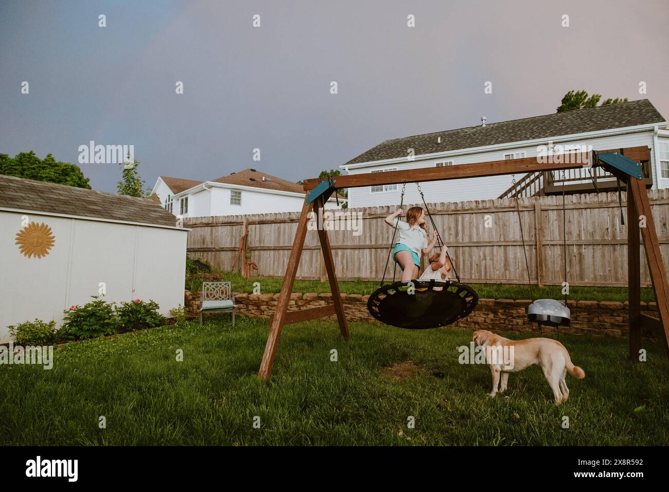 Kids Playing outside with dog on swing set with Rainbow Stock Photo - Alamy