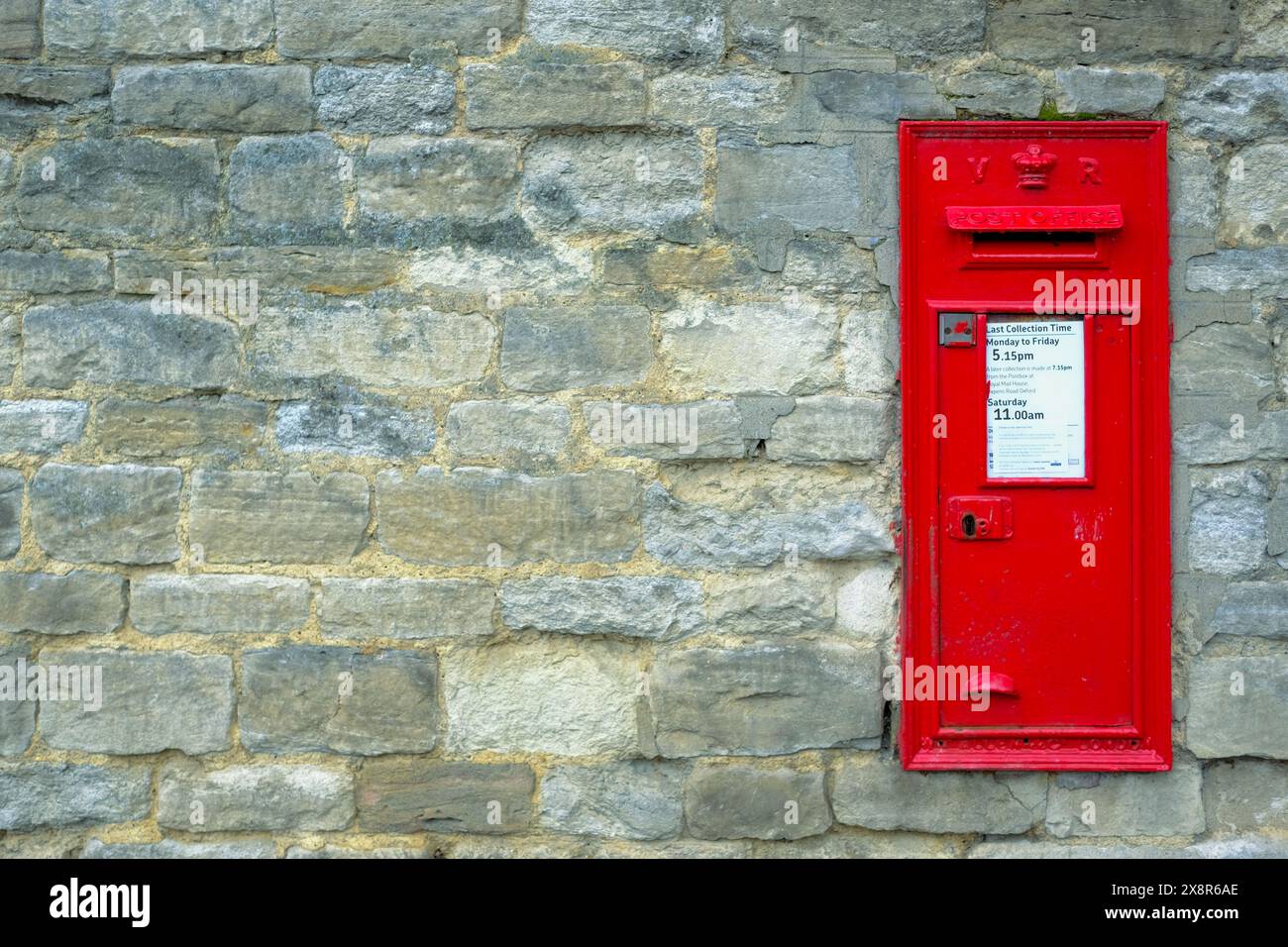 A rectangular red post box built into the wall on a street in Oxford ...