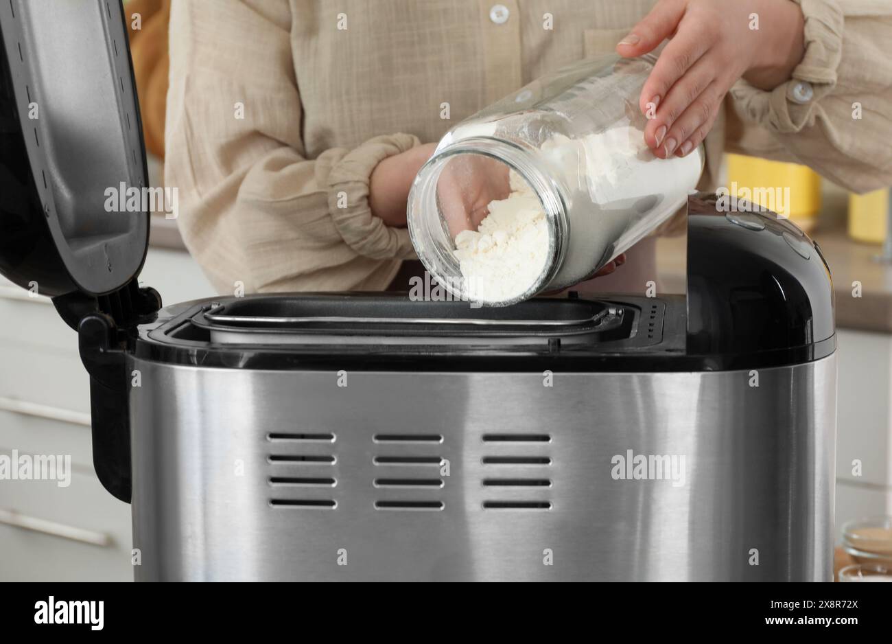 Making dough. Woman adding flour into breadmaker machine, closeup Stock ...