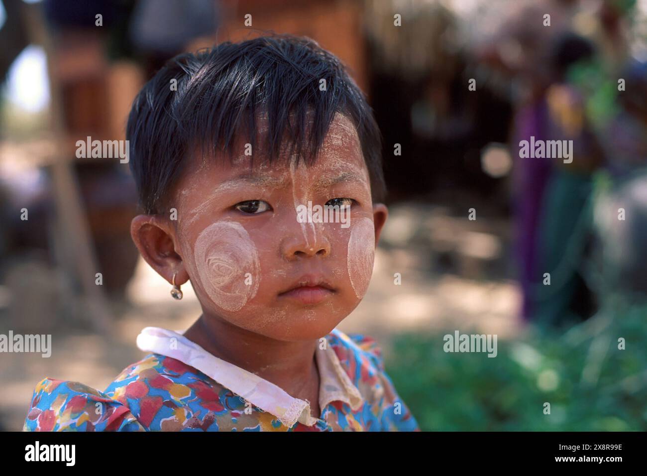 Burmese girl with thanaka paste on her cheeks hi-res stock photography ...