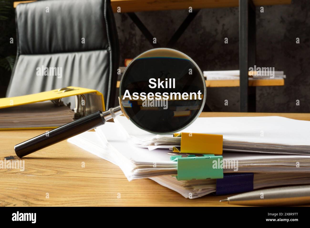 Skill assessment concept. A stack of papers and a magnifying glass with ...