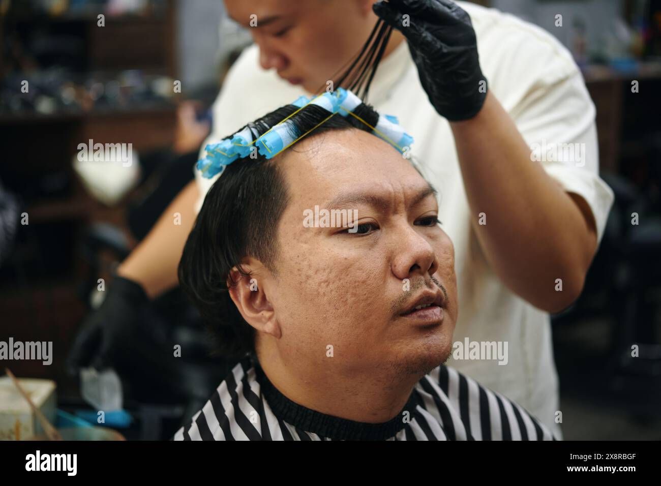 Vietnamese man getting hair perming procedure in beauty salon Stock ...