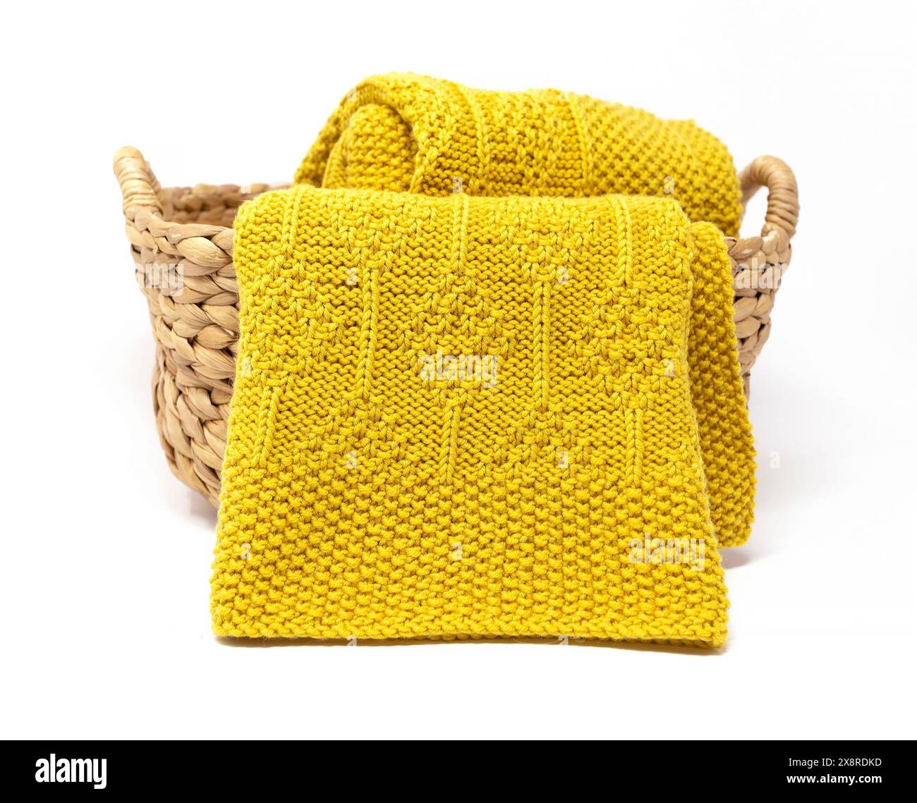 Yellow wool knitted blanket in diamonds pattern in basket on white ...