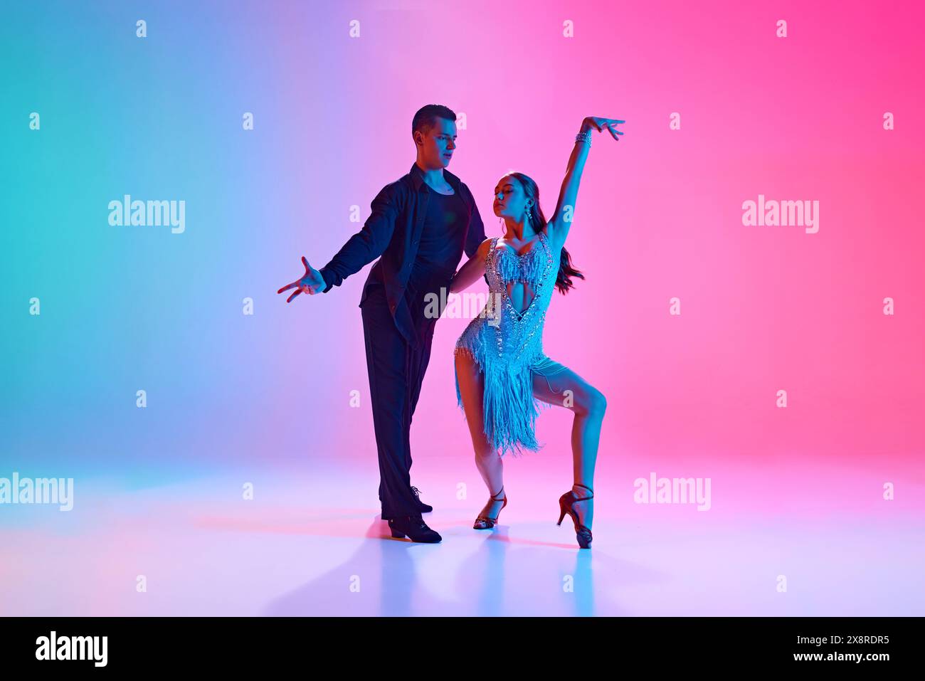 Duet of ballroom dancers, man and woman, in stage costumes posing in ...