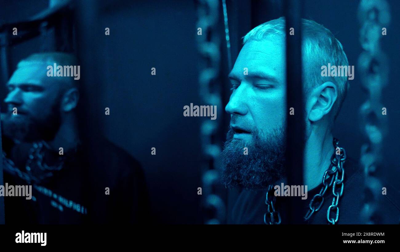 A young stylish man at the event standing with chains around his neck ...