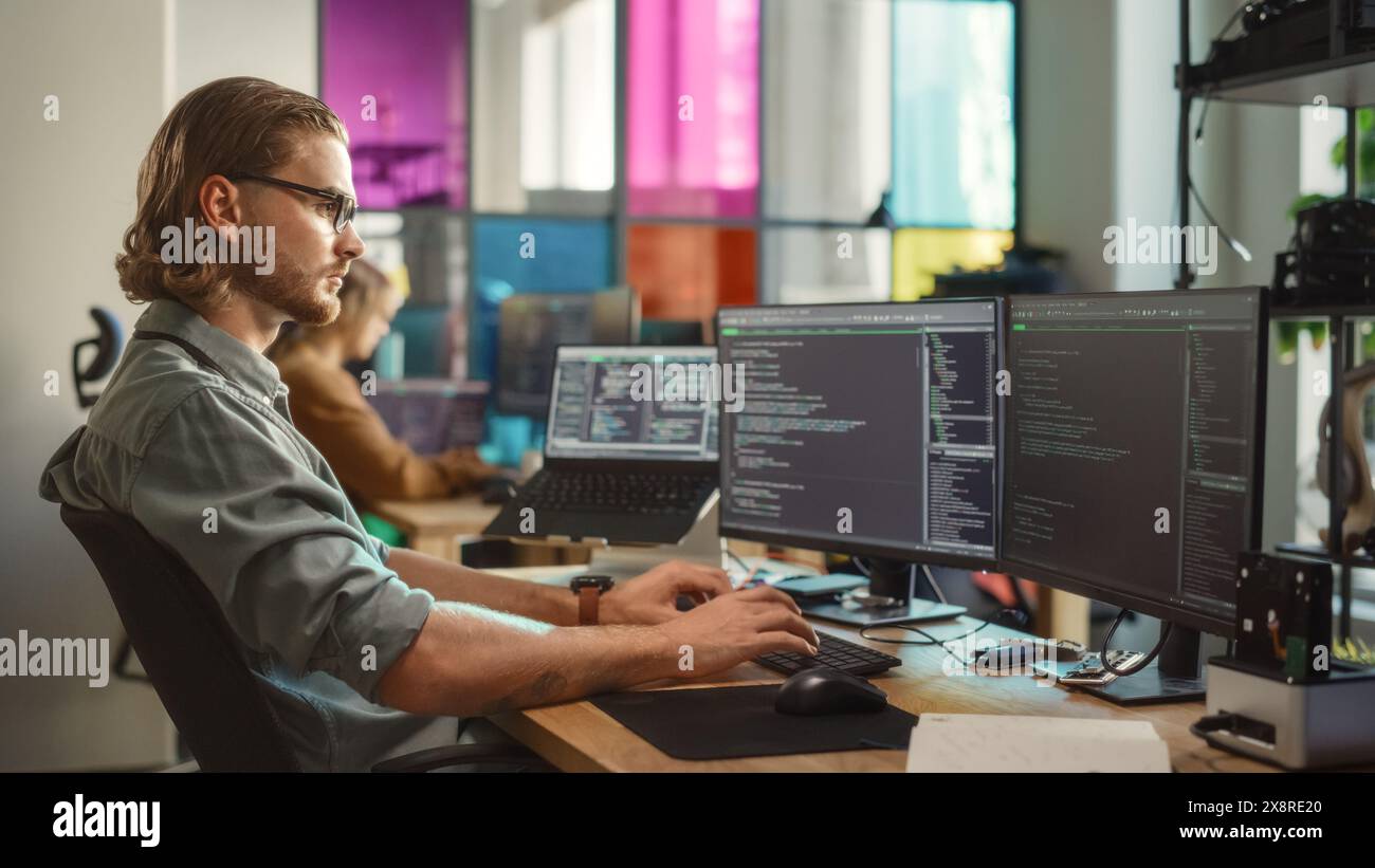 Developer using multiple displays coding hi-res stock photography and ...