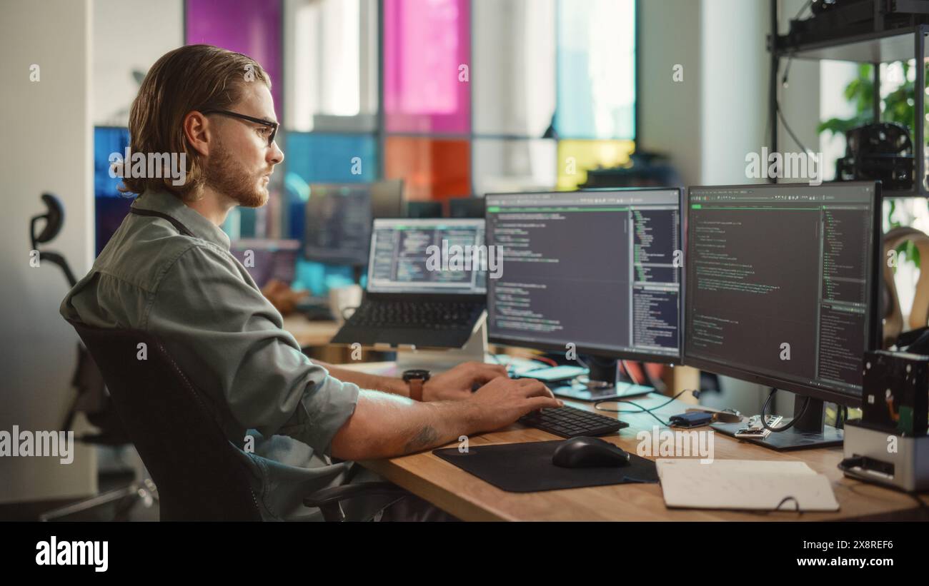 Developer using multiple displays coding hi-res stock photography and ...