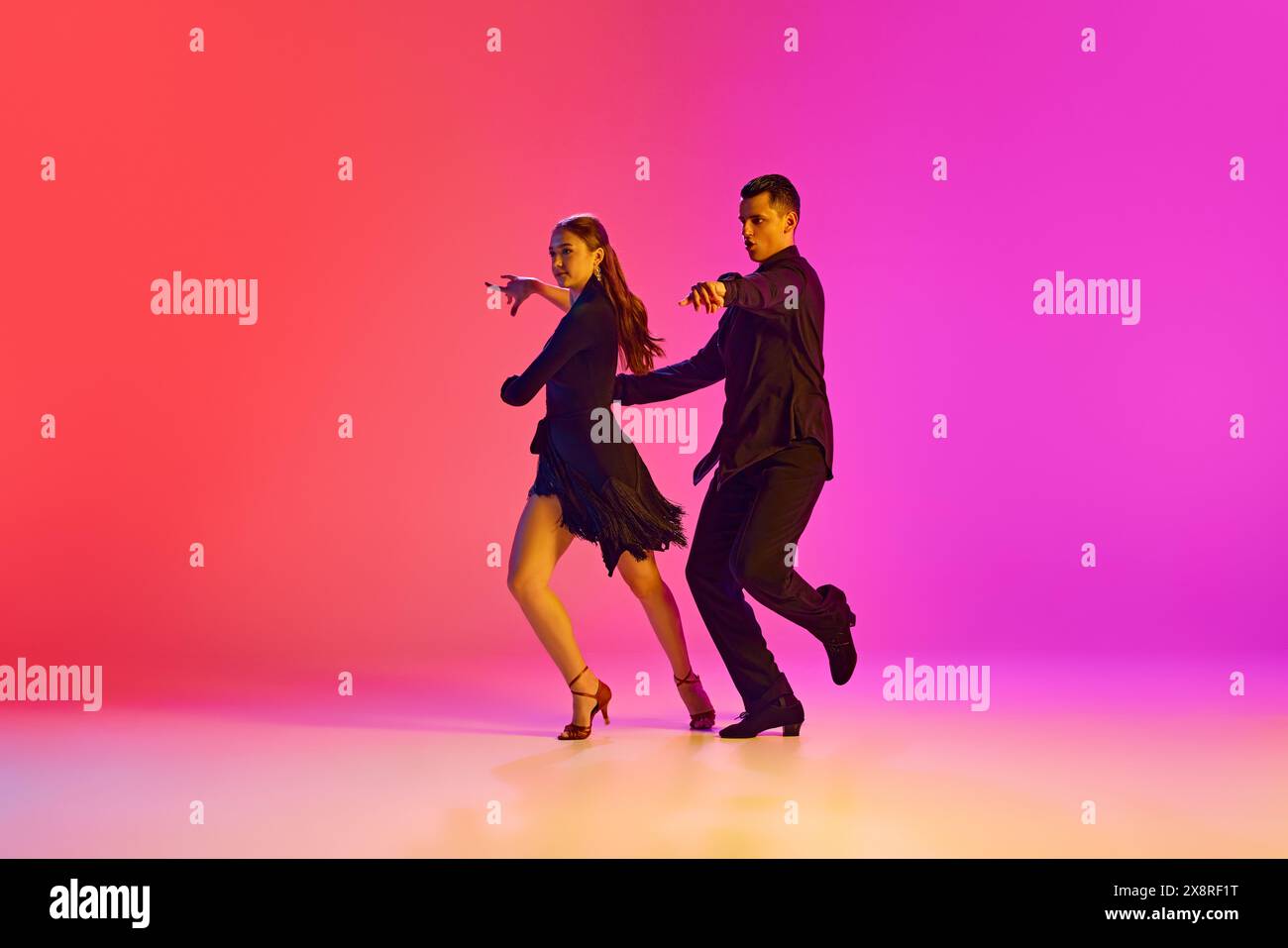 Duet of ballroom dancers, man and woman in festive costumes moving in ...