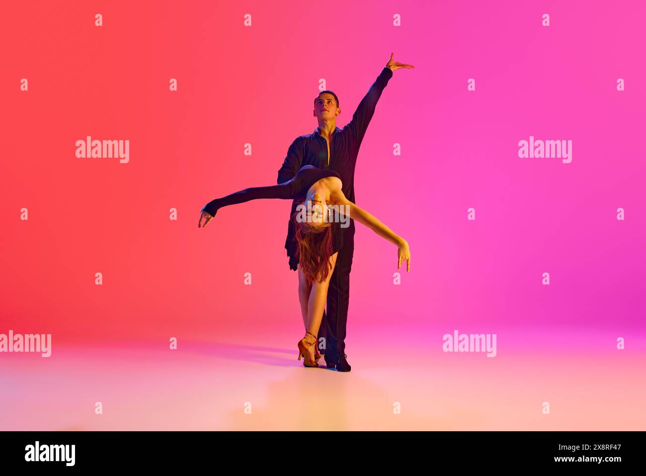 Duet of ballroom dancers, man and woman, in stage costumes posing in ...