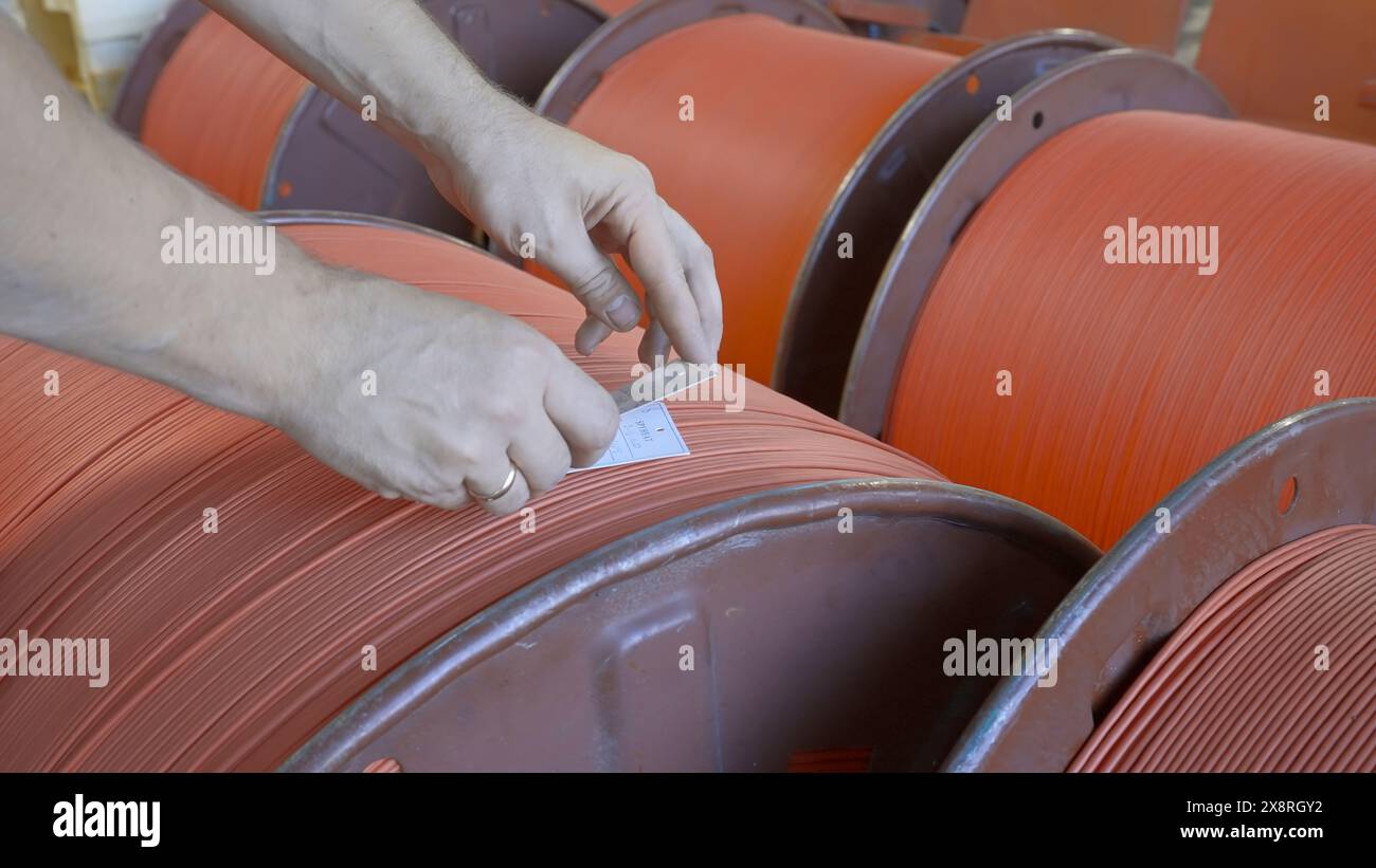 Close-up of worker with wires on coils in factory. Creative. Worker ...