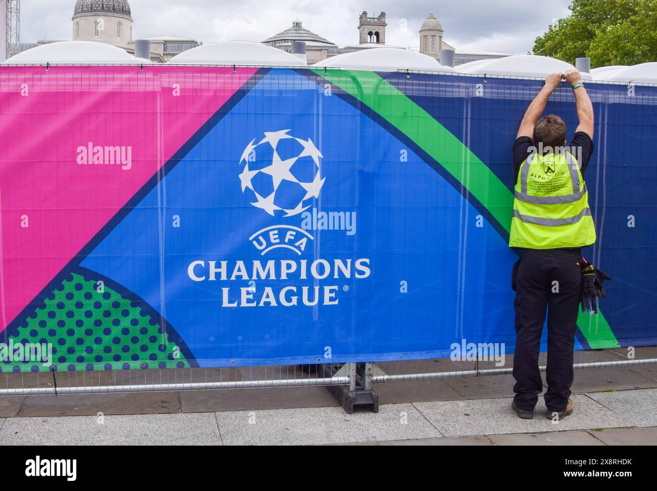 London, UK. 27th May 2024. A worker installs banners for the Champions ...