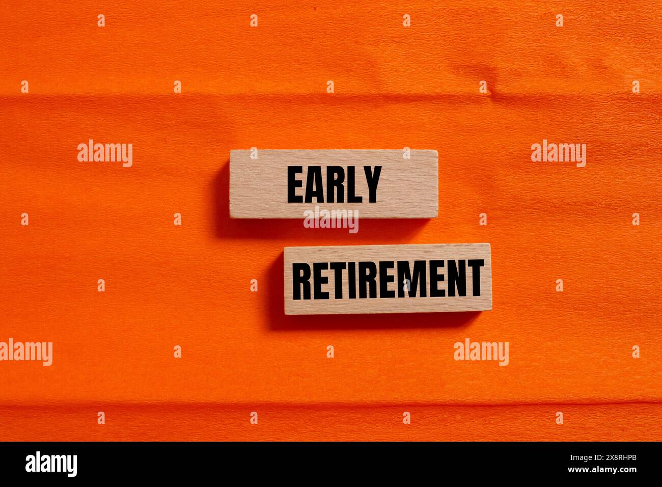 Early retirement words written on wooden blocks with orange background ...