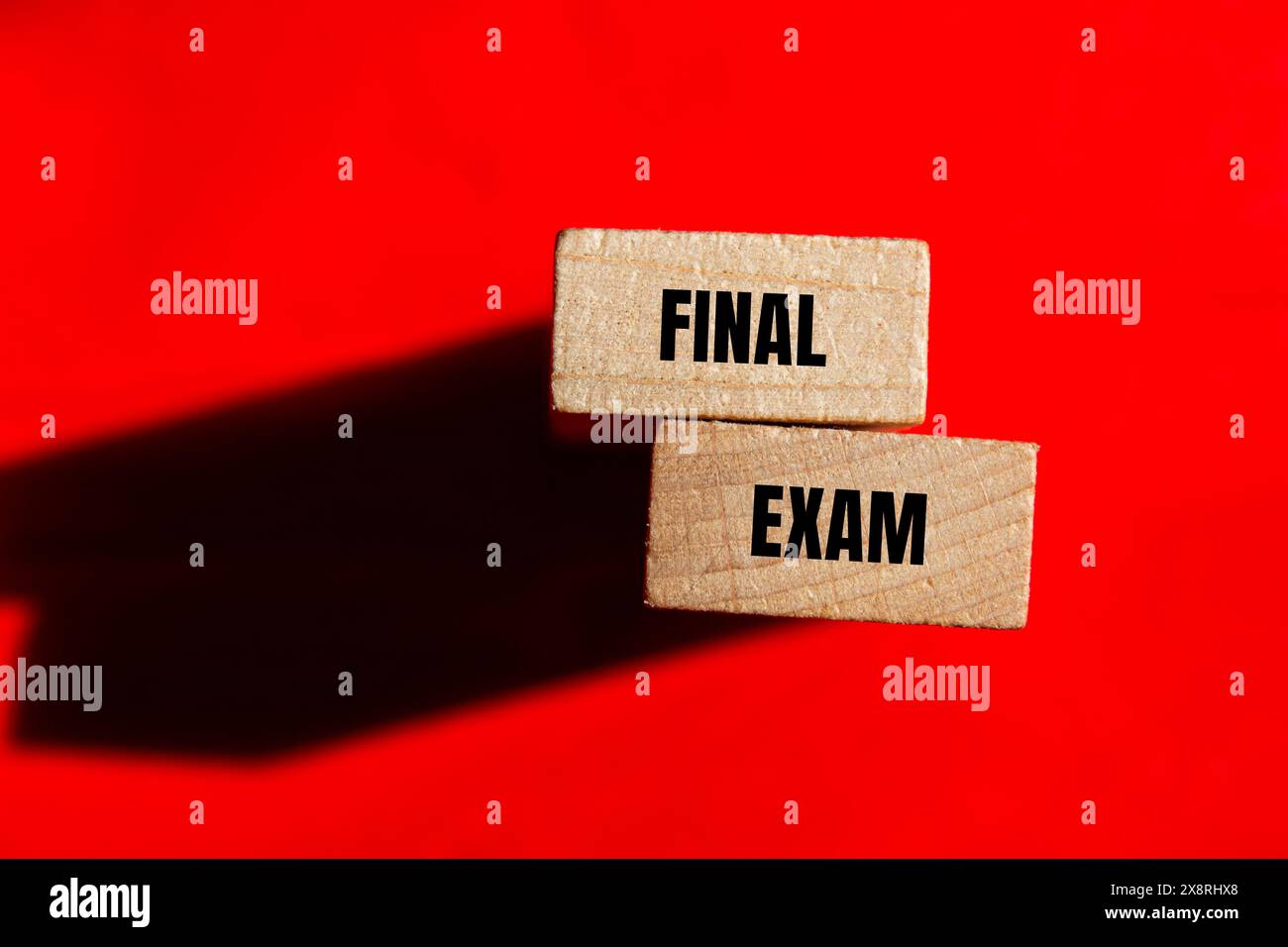 Final exam words written on wooden blocks with red background ...