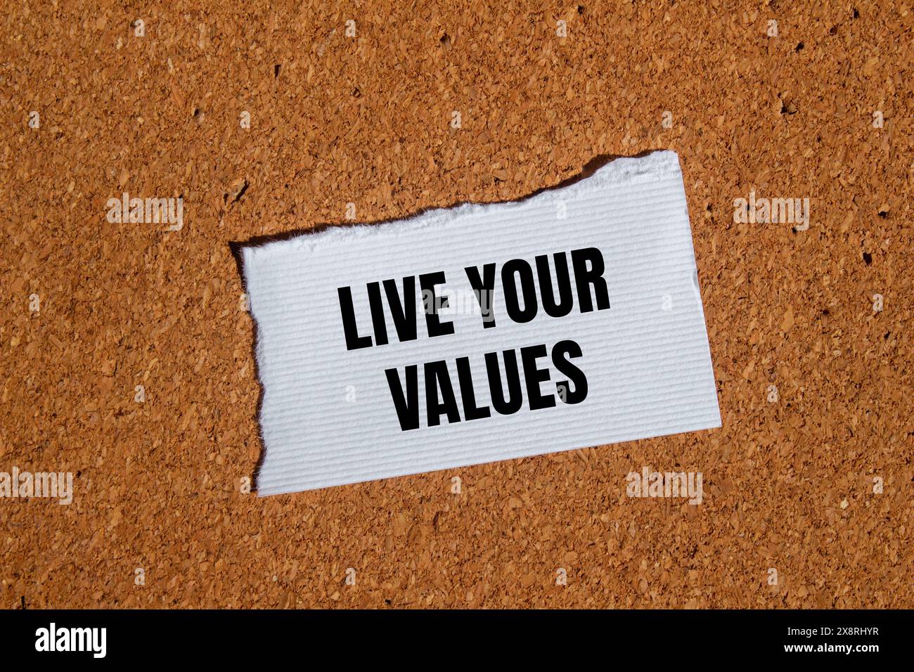 Live your values words written on ripped white paper piece with brown ...