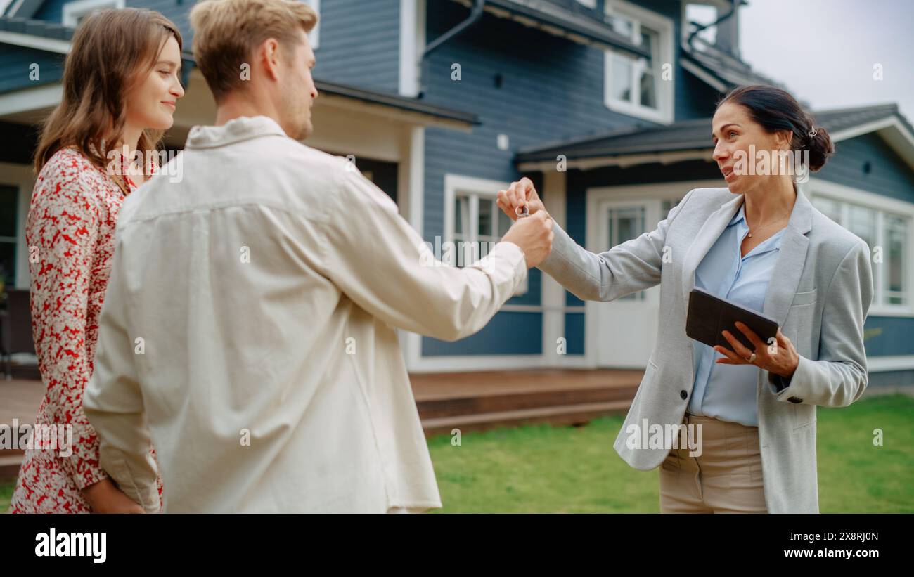 Happy Real Estate Agent Congratulating Young Homeowners with Their New ...