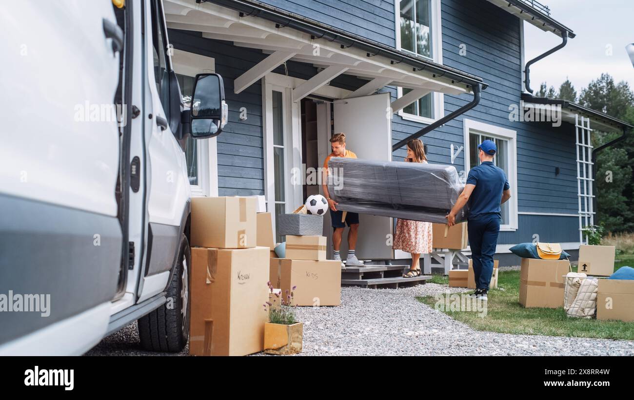 Young Man Helping a Delivery Service Worker to Bring a Modern Couch ...