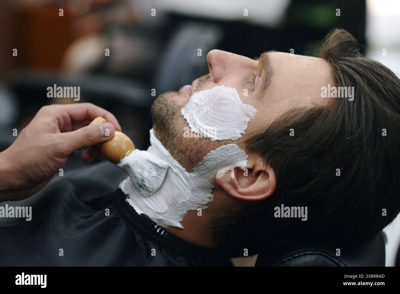 Barber using cream when shaving neckline of client Stock Photo - Alamy