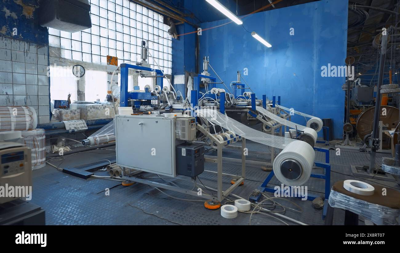 Industrial production of plastic grids. Creative. Machines winding thermoplastic meshes made of ...