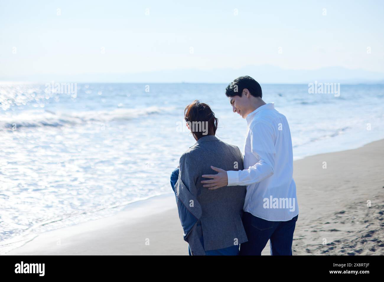 Couple snuggle together on beach hi-res stock photography and images ...