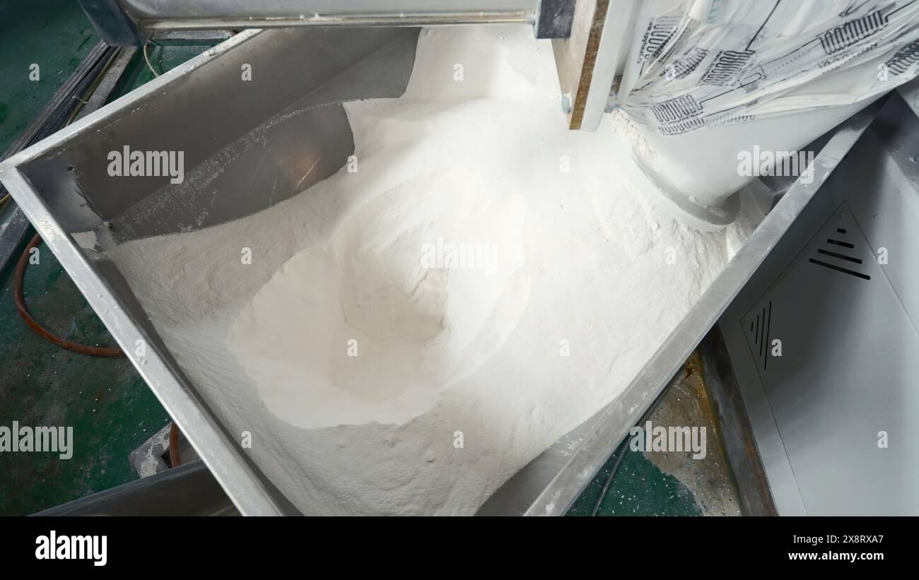 Plastic powder at factory. Creative. Pipe with spilling plastic powder ...