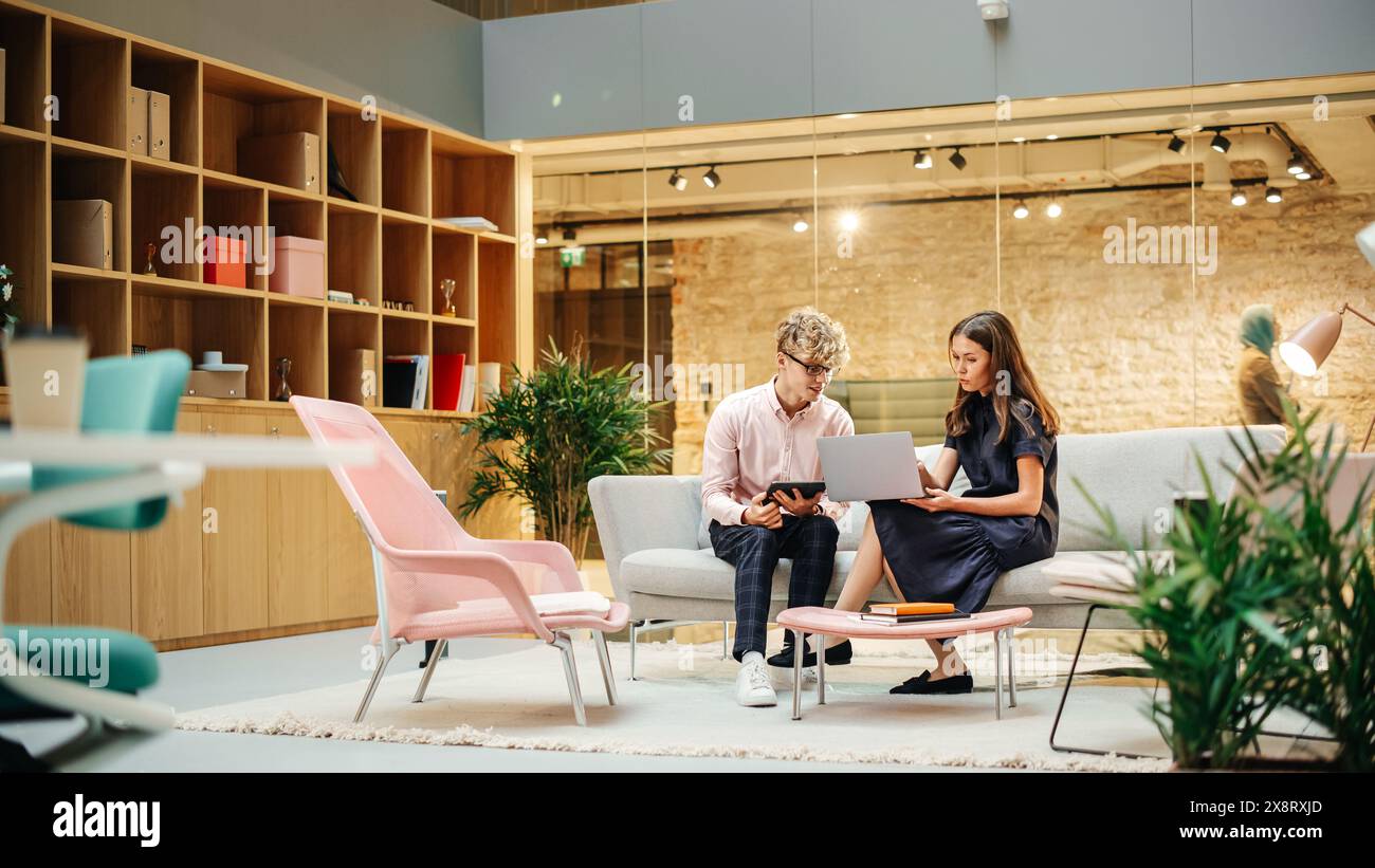 Portrait of Two People Collaborating and Pointing at the Laptop Screen ...