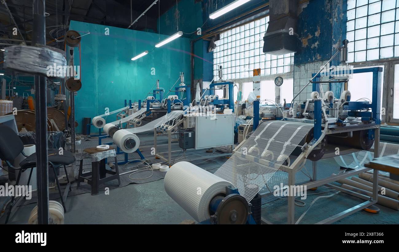 Industrial production of plastic grids. Creative. Machines winding ...