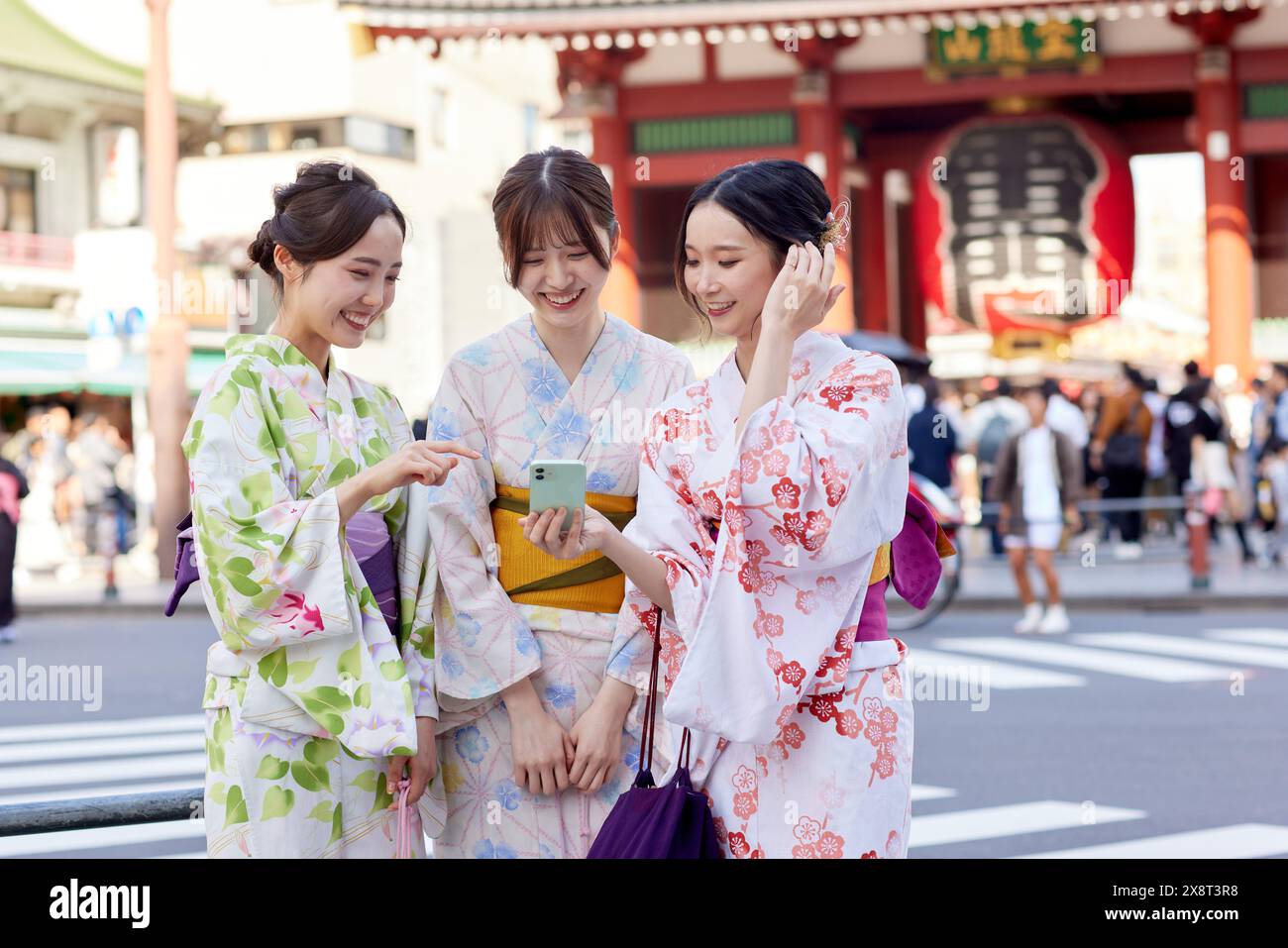 Japanese friends wearing yukata visiting traditional temple in Tokyo ...