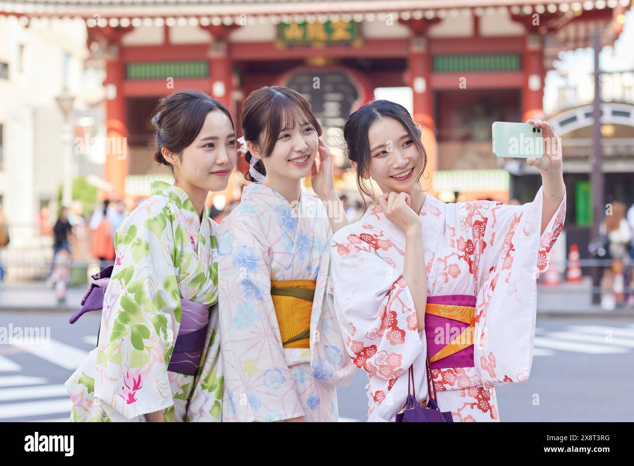 Japanese friends wearing yukata visiting traditional temple in Tokyo ...