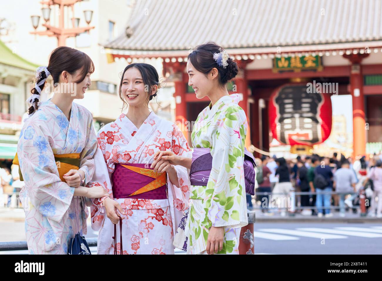 Japanese friends wearing yukata visiting traditional temple in Tokyo ...