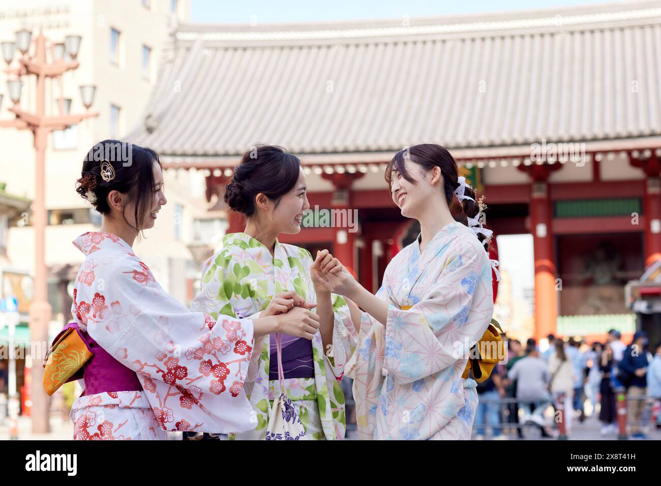 Japanese friends wearing yukata visiting traditional temple in Tokyo ...